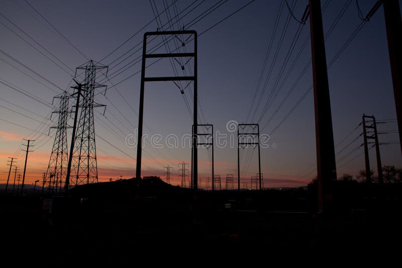 Vibrant Sunset Over an Open Field with High-voltage Power Lines in the ...