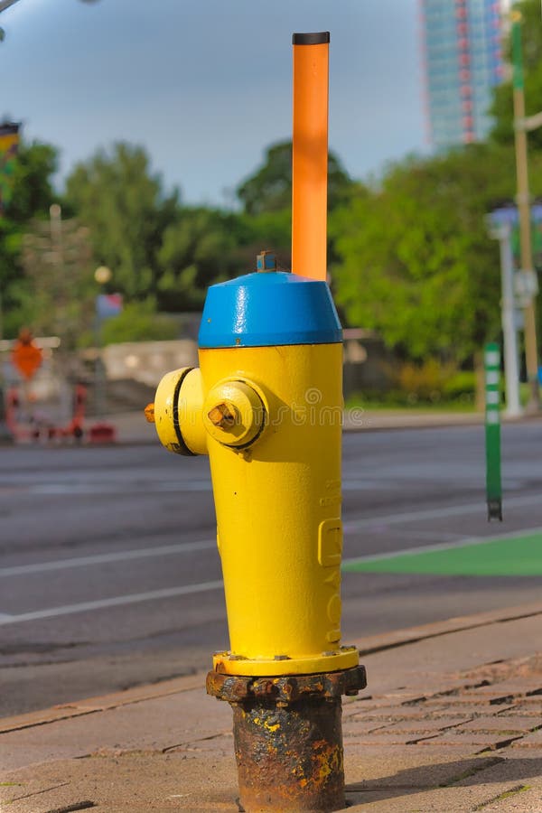Vibrant Yellow Fire Hydrant with Blue Cap on a Sunny Street Corner ...