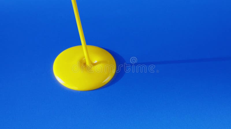 Vibrant Yellow Paint Dripping Gracefully on a Blue Surface an Artistic ...