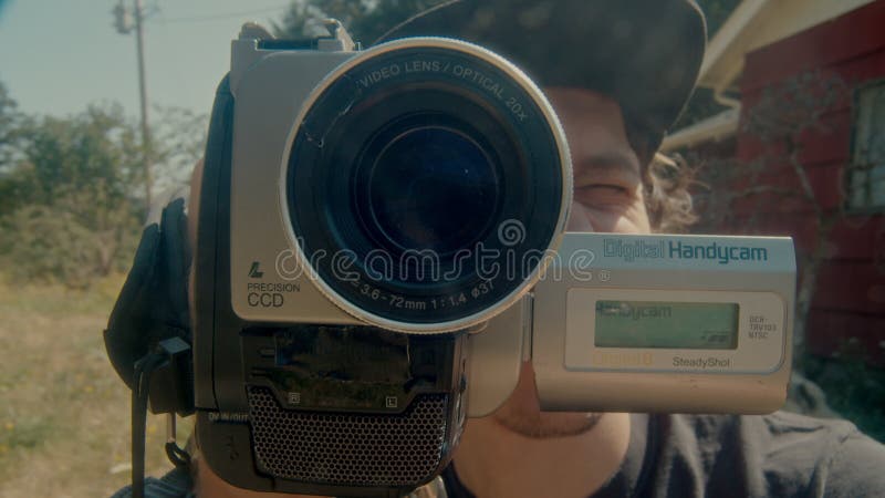 Video Camera Front View and a Young Man with a Cap Shooting Footage on ...