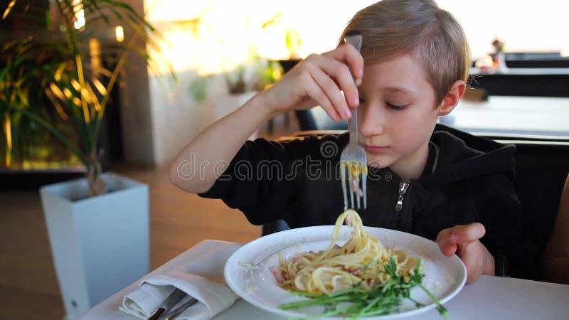 A Child in a Restaurant Twists Carbonara Paste on a Fork Stock Footage ...