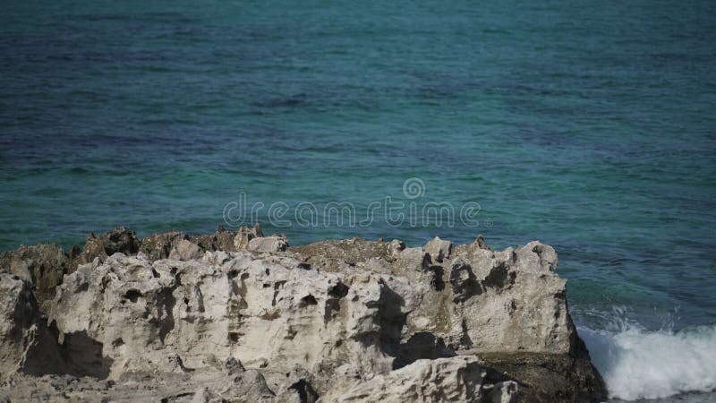 Loopable Video of a Smooth Cliff Rock Hit by Crystal Clear Sea Waves ...