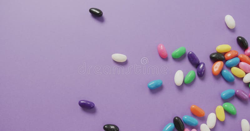 Video of Overhead View of Multi Coloured Sweets Falling Over Purple ...