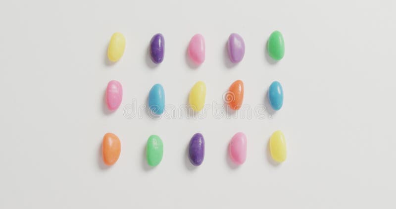 Video of Overhead View of Rows of Multi Coloured Sweets Over White ...