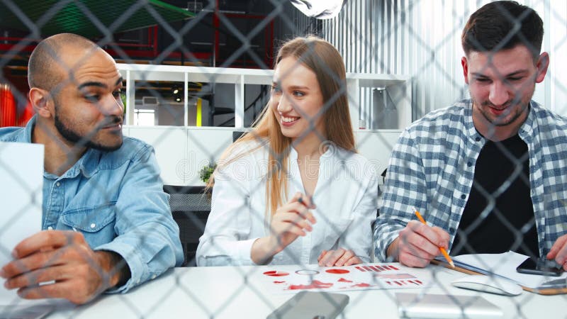Modern Office Workers Collaborate on Project Behind Chain Link Fence ...