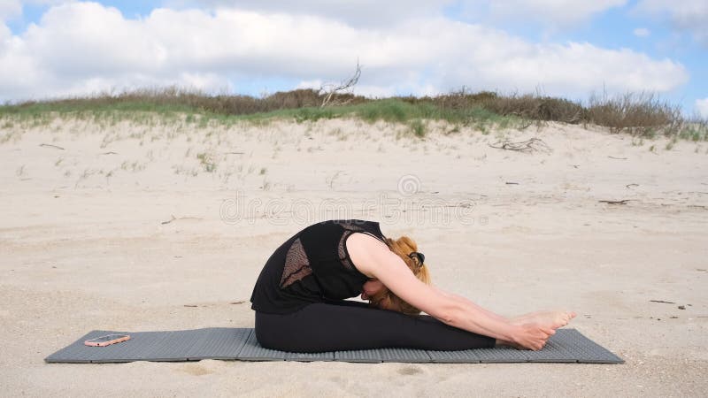 Video of a Woman Practicing Yoga Outdoors on Sandy Surface, Performing ...