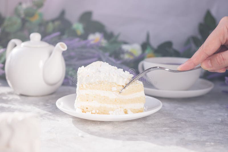 The Viel Breaks Off a Piece of Cake on a White Table among the Flowers ...