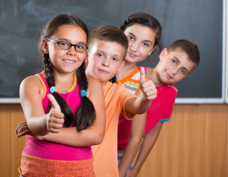 Vier Lächelnde Schulkinder, Die Im Klassenzimmer Stehen Stockbild ...