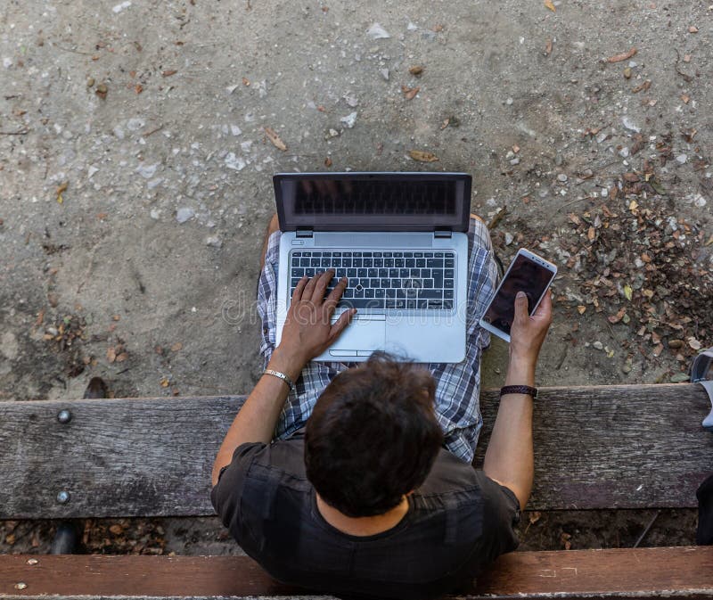 View from Above of a Digital Nomad Using His Computer and His Mobile ...