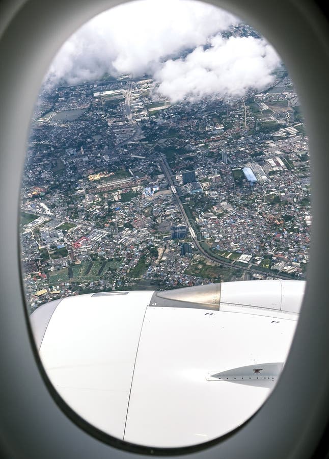 View from an Airplane Window Showcasing Urban Landscape and Cloud ...