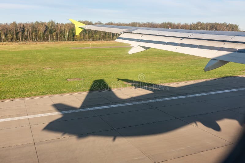 View of Airplane Wing, Shadow of the Plane on the Ground during Landing ...