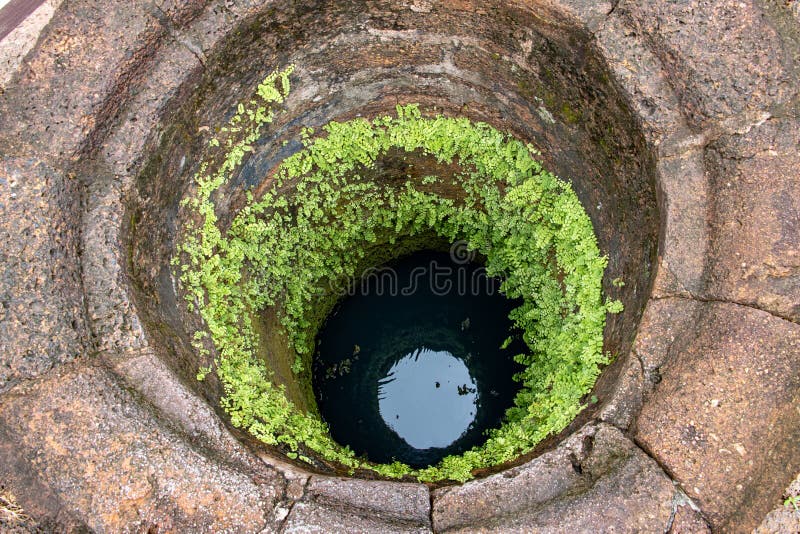 A View into an Ancient Well with a Dark Water Surface in Depth Stock ...