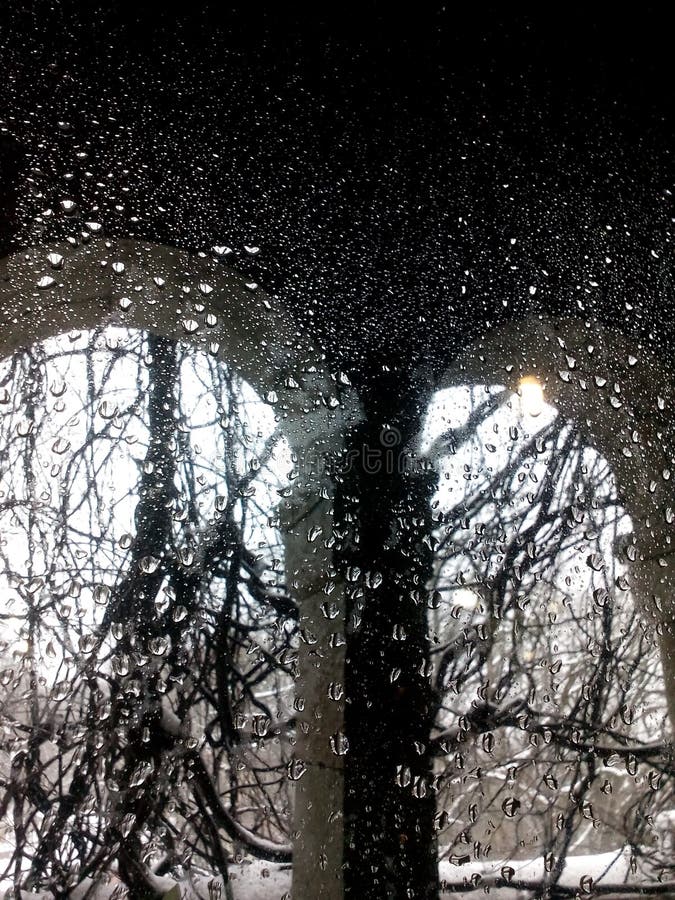View of Arches and Trees in the Snow through a Window with Drops Stock ...