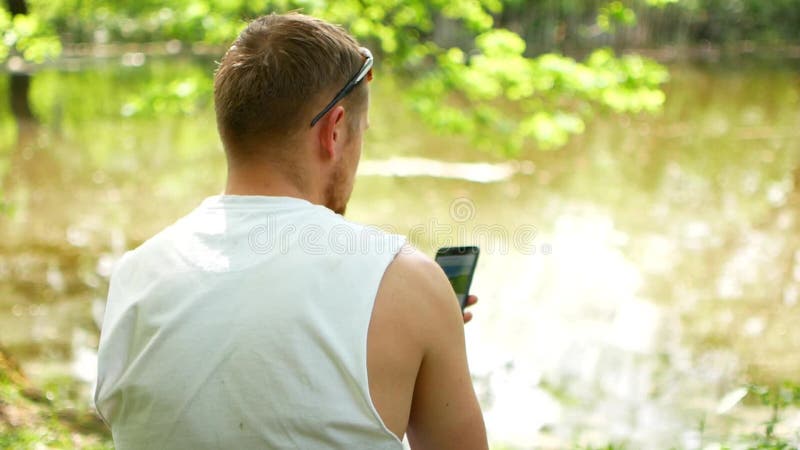 View from Back of a Man Using Smartphone Stock Video - Video of leaves ...