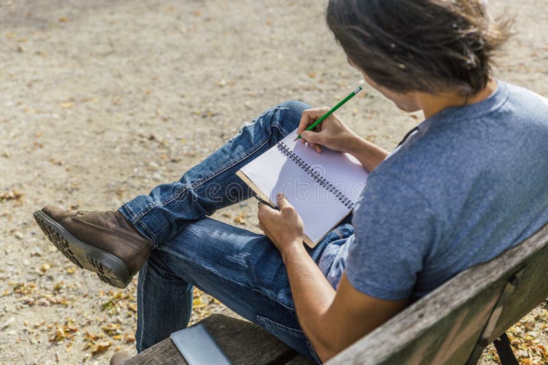 View from the Back of a Young Writer Dressed in Blue Jeans Who Writes ...