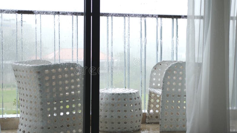 View of the Balcony with Table and Chairs in the Pouring Rain with ...