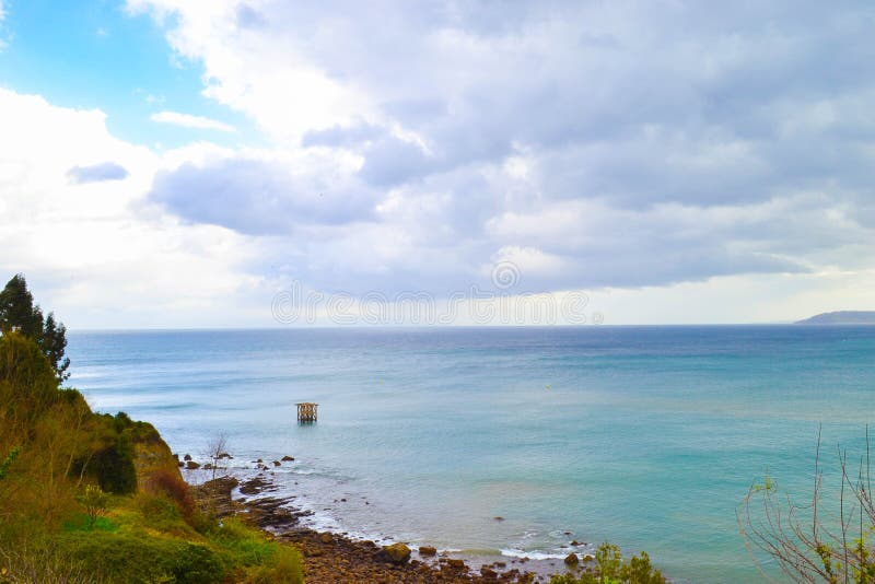 View of a Beach in Front of Cliffs and Hills, with Green Mountains and ...