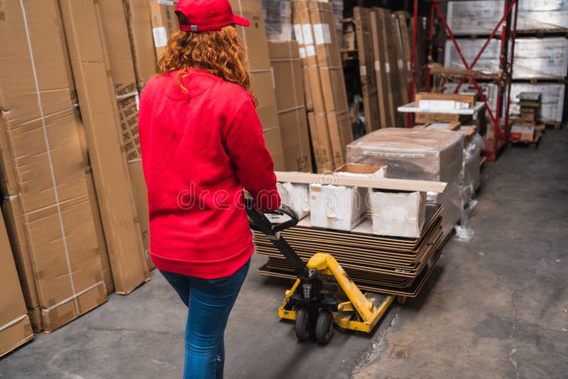 View from Behind Female Worker with a Pallet Truck in a Warehouse Stock ...