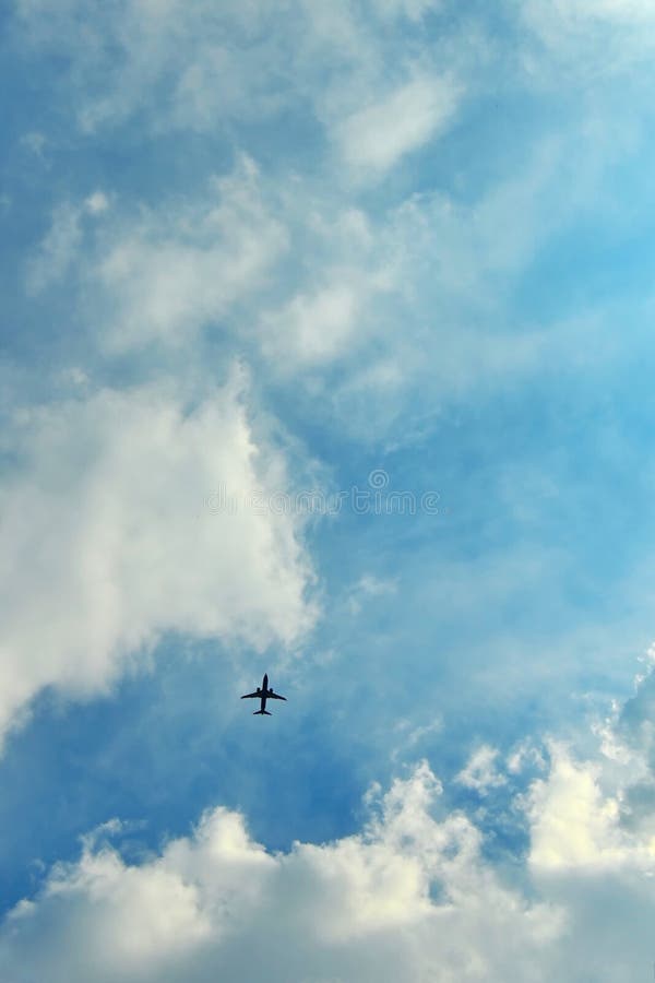 View from Below of Airplane in Flight Under Blue Cloudy Sky Stock Photo ...