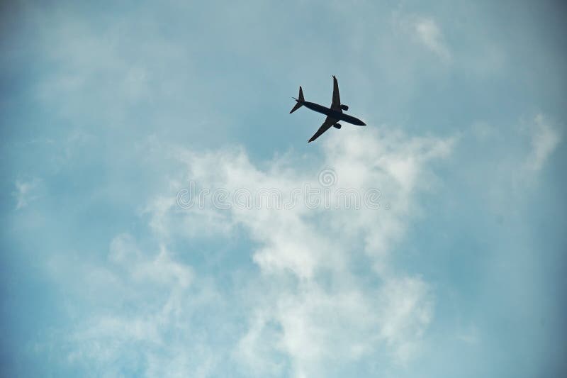 View from Below of Airplane in Flight Under Blue Cloudy Sky Stock Image ...