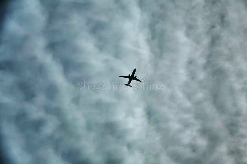 View from Below of Airplane Silhouette Flying Under Cloudy Sky Stock ...