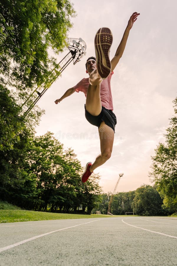 View from Below of an Athlete Running Fast in a Race on the Athletics ...