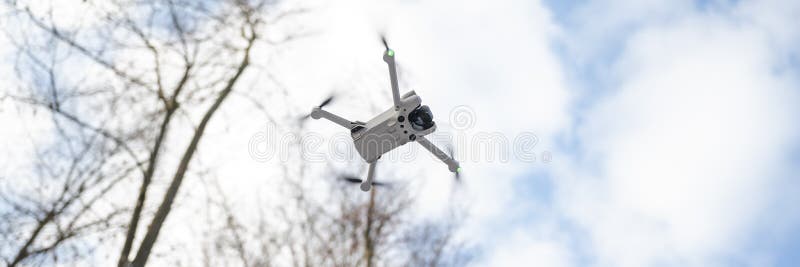 View from Below of a Drone Floating in the Air Under a Blue Sky with ...