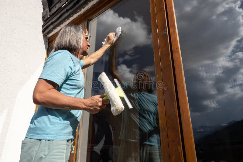 A View from Below of a Man Wiping Panoramic Windows from the Street ...