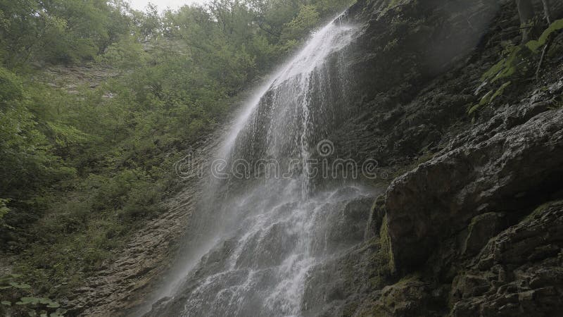 View from Below of Waterfall Flowing Down Cliff in Forest. Action Stock ...