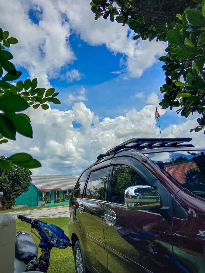 A View of Blue Skies with Multiple Vehicles Parked in the Driveway ...