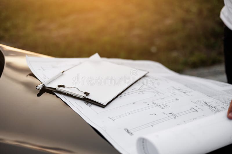 View on Blueprints of Construction, Clipboard with Notes at Car Hood at ...