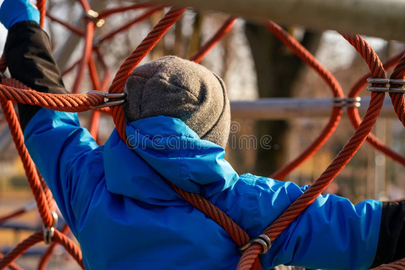 View of a Boy in a Blue Jacket on the Ropes at the Playground Stock ...