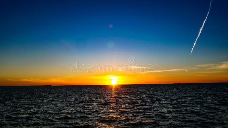View of Bright Sun Setting Down Over Calm Sea Stock Photo - Image of ...