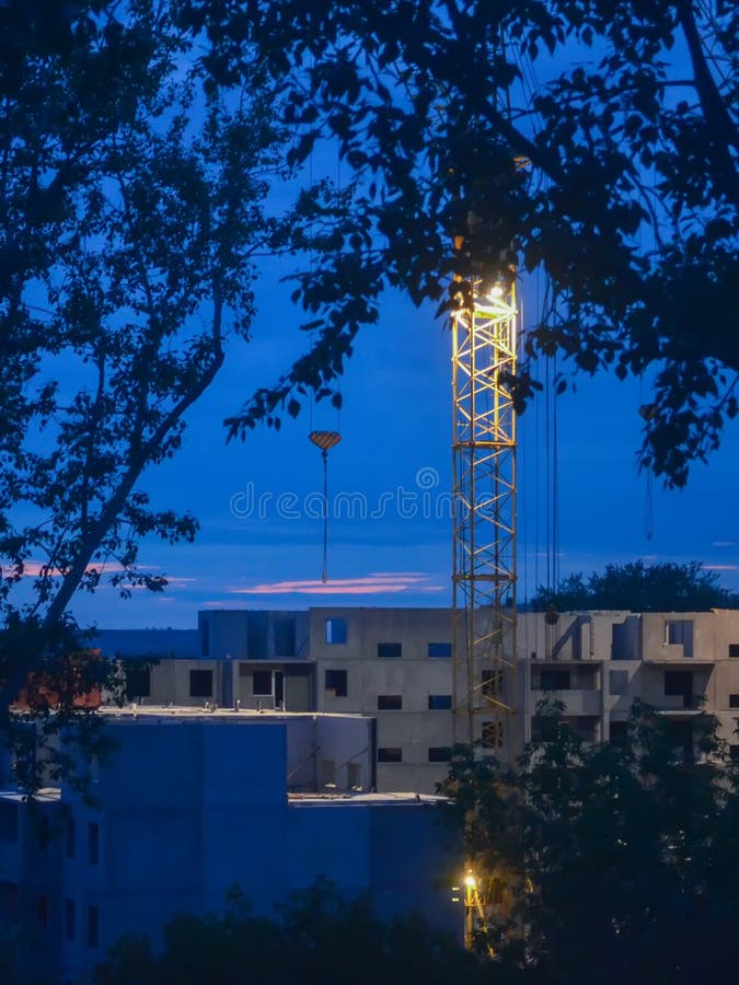 A View of the Building Under Construction and the Crane in the Twilight ...