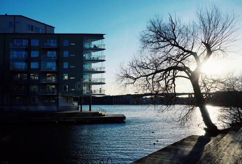 View of Buildings at Waterfront Stock Image - Image of water, sunset ...