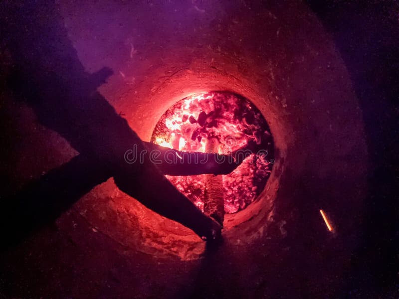 View of Burning Embers and Charred Wood Inside a Fire Pit, Casting a ...