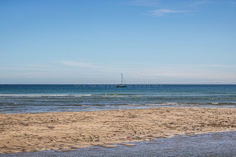 View of a Calm Sea with a Boat on the Horizon and a Sandy Shoal in the ...