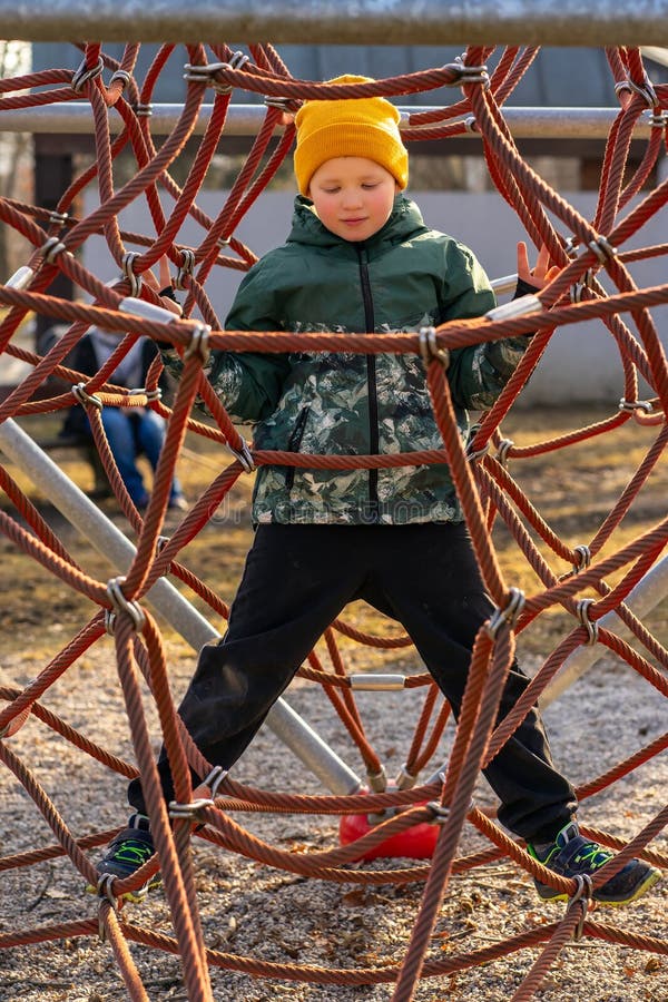 View of a Child Climbing an Alpine Net in a Park on a Playground on a ...