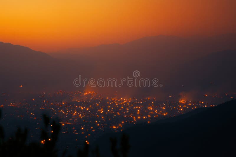 A View of a City at Night from a Hill with Bright Lights and Buildings ...