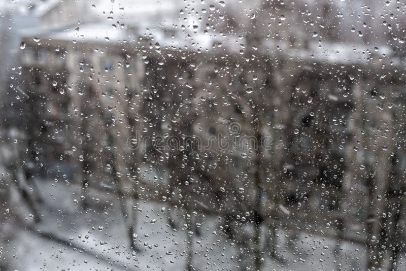 View of the City in a Snowfall through a Window Covered with Water ...