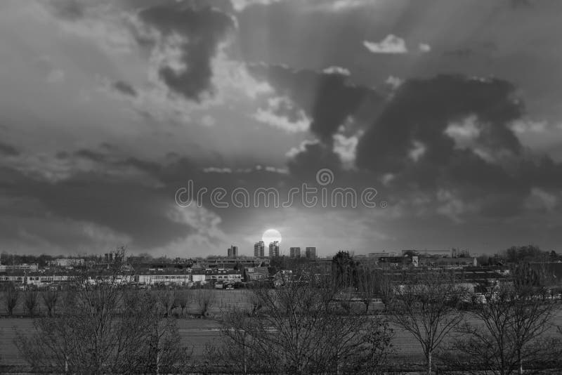 View of a City and the Sun Lights in the Sky with Clouds in Grayscale ...