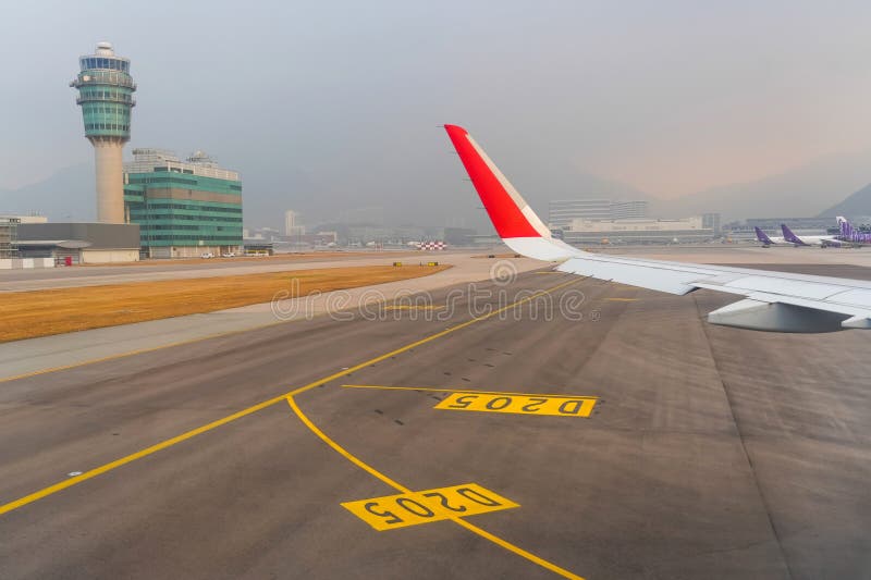 View of the Control Tower and Passenger Terminal with an Airplane Wing ...
