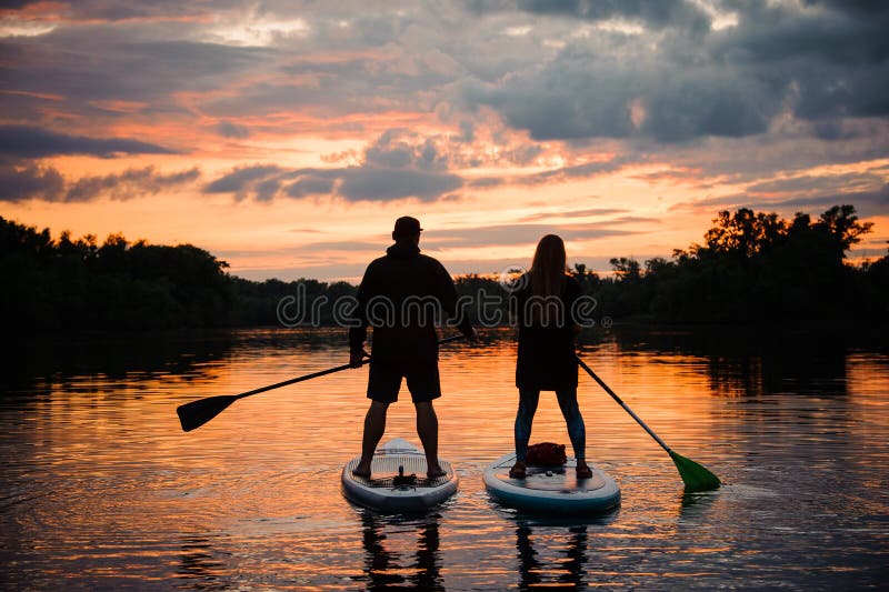 View on Couple of People on Sup Boards on the River at Sunset Stock ...