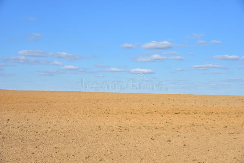 View of a Deserted Sand Field Against a Blue Sky with Clouds Stock ...