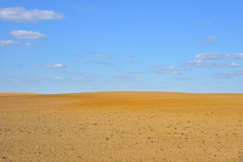 View of a Deserted Sand Field Against a Blue Sky with Clouds Stock ...