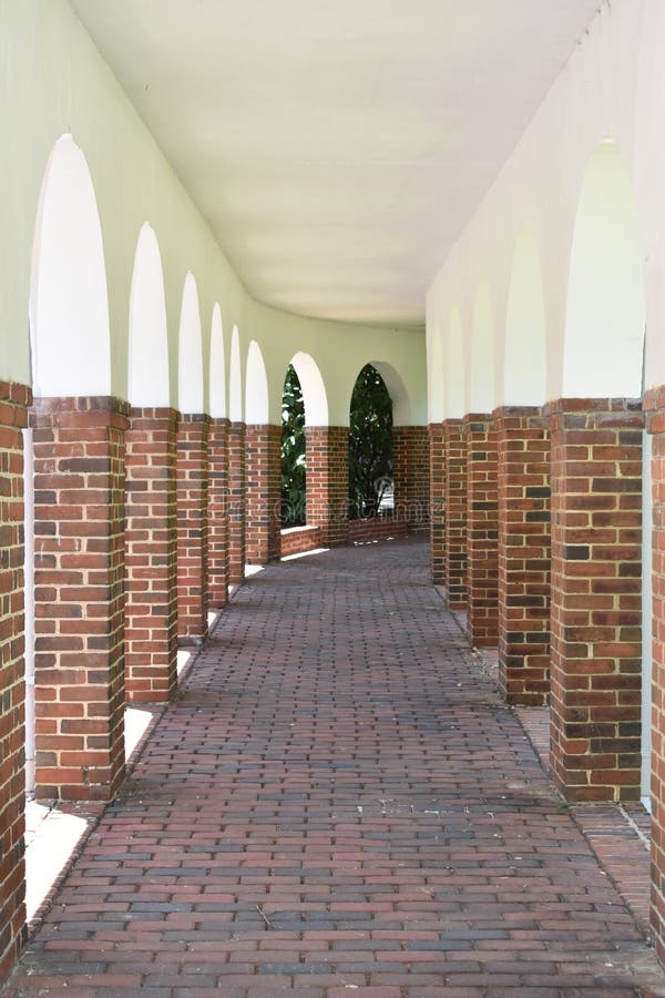 View Down a Long Walkway with Brick Archways and a White Ceiling. Stock ...