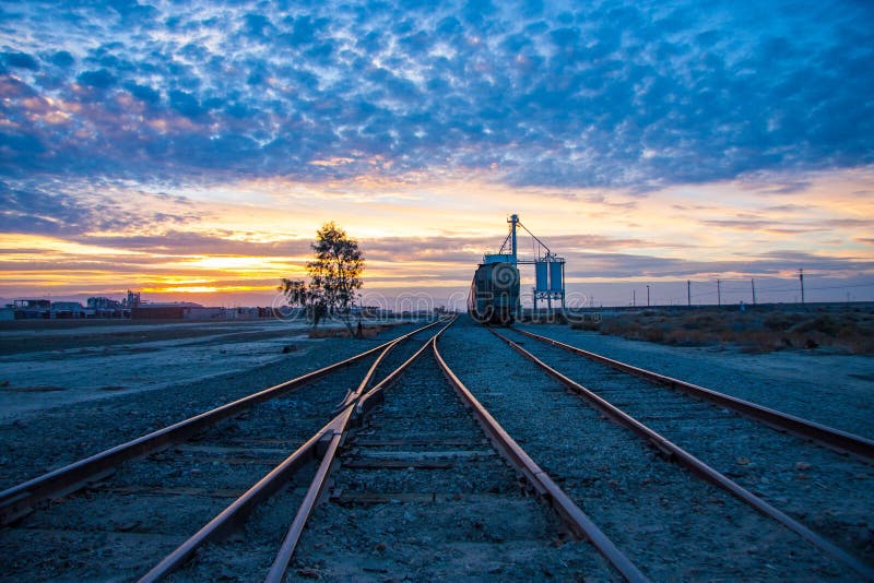 View Down Railroad Tracks at Sunset Stock Photo - Image of tracks ...