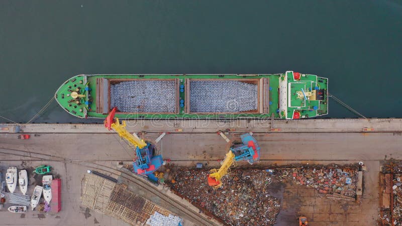 A Crane Loading Scrap in Cargo Ship Vessel at Recycling Metal Plant ...