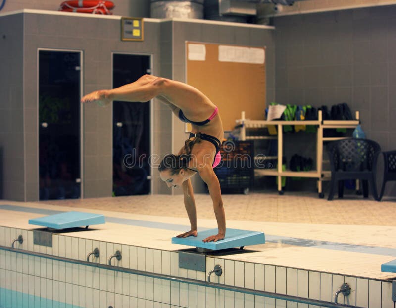 View of a Female Diver Diving into the Pool. Standing on Arms with Legs ...
