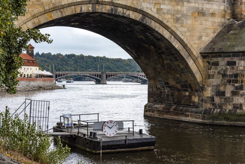 The Ferry with Clocks Under the Arch of Charles Bridge in Prague, Czech ...